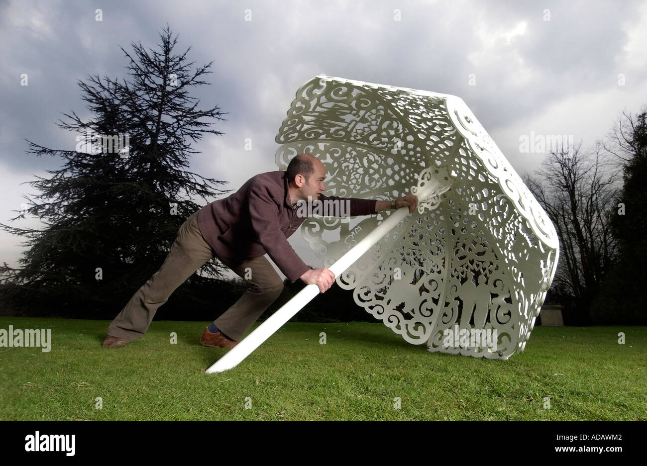 Sculptor Bruce Williams arranges his steel parasol in the garden of ...