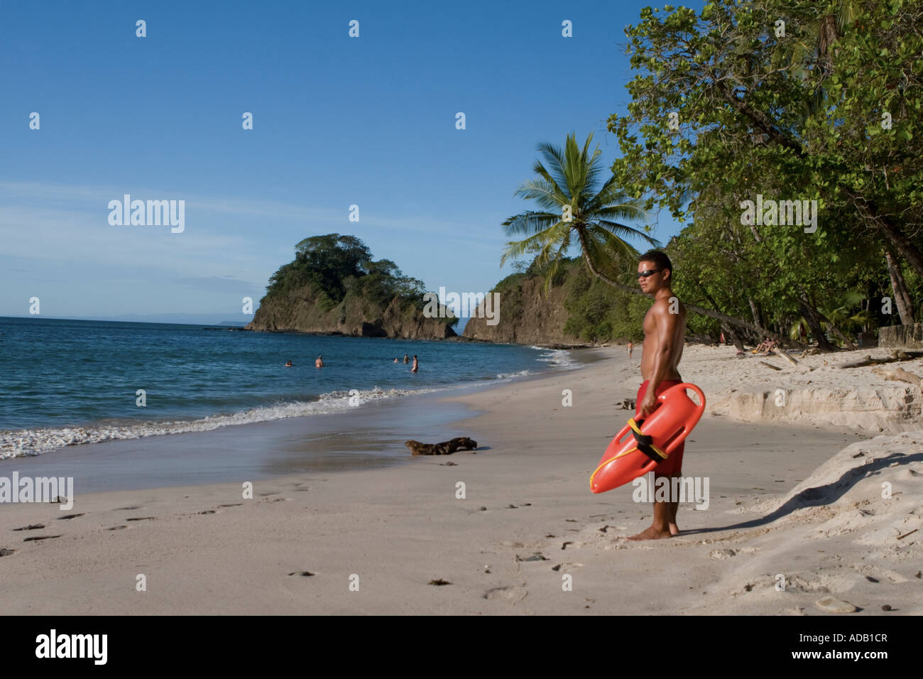 life guard on duty at the beach holding a floating floatation device ...