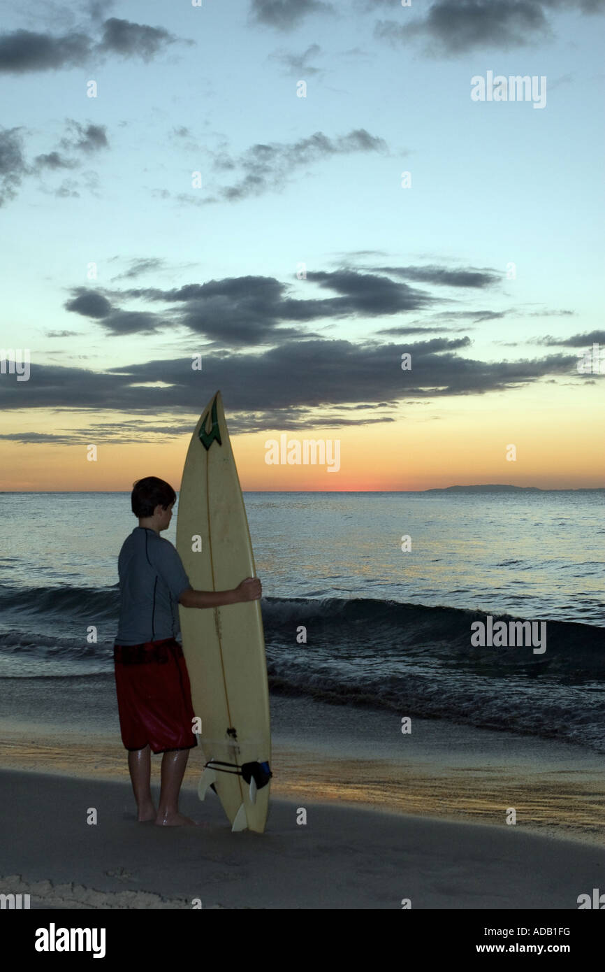 boy stands with his surf board watching the sunset Stock Photo - Alamy