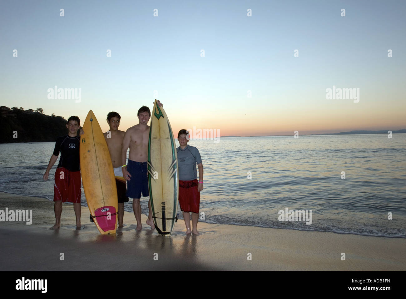 Group photo at the beach with surf boards Stock Photo - Alamy