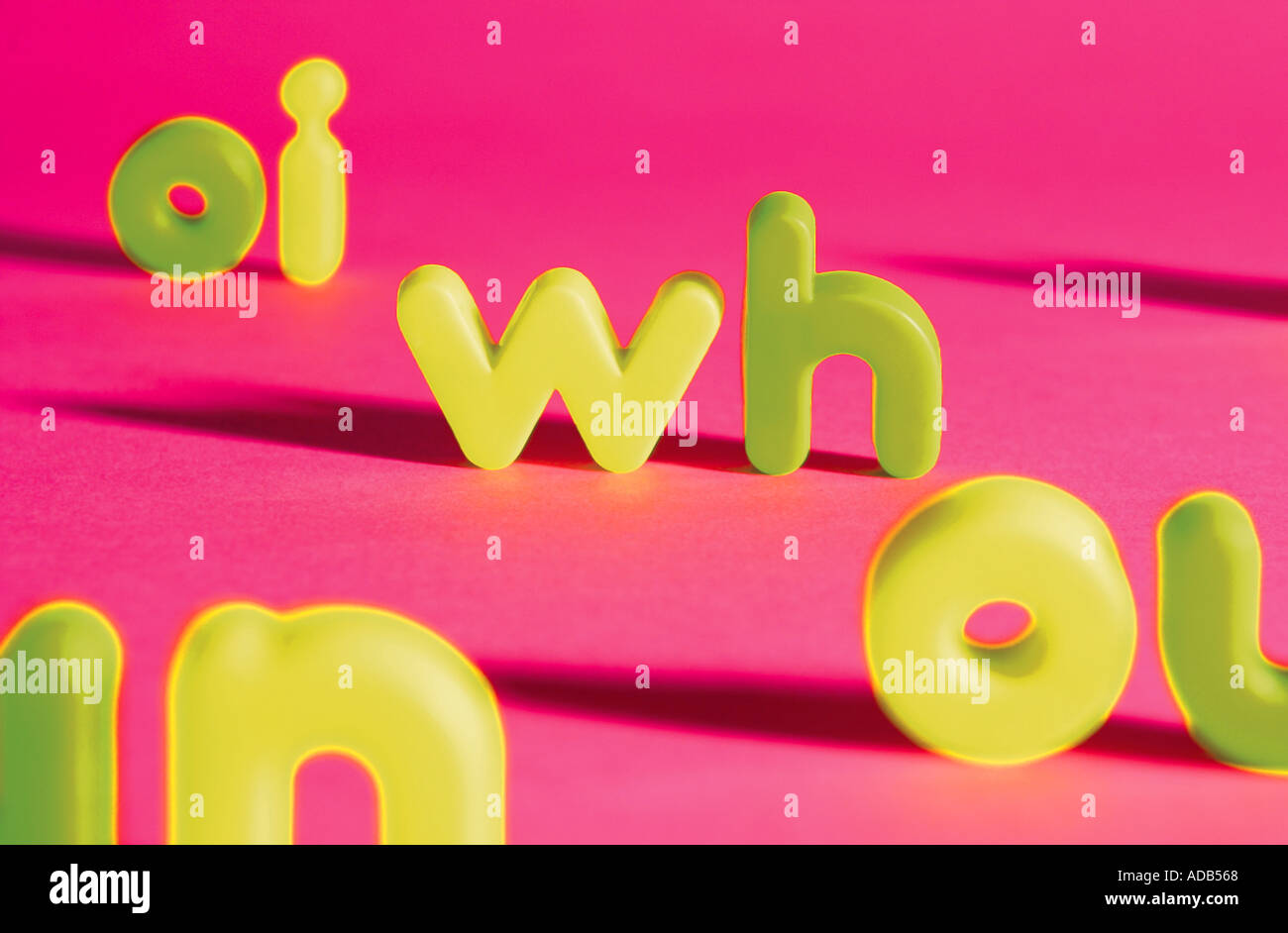 Childrens green and yellow magnetic letters on pink background spelling ...