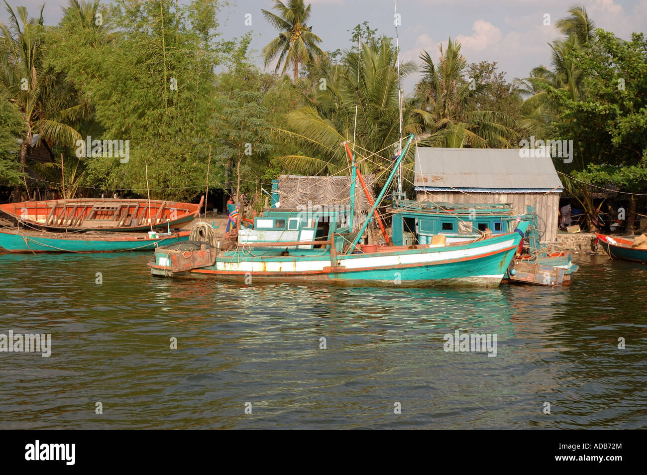 Fishing boat alongside Riverside Huts in Kampot, Cambodia Stock Photo ...