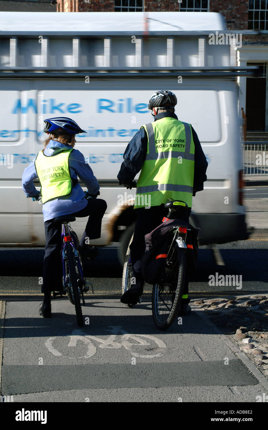 Road Safety Two cyclists wearing safety helmets on a cycleway stop at ...