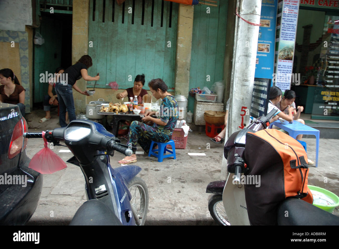 Vietnamese eating in a typical outdoor street restaurant in Hanoi Stock ...