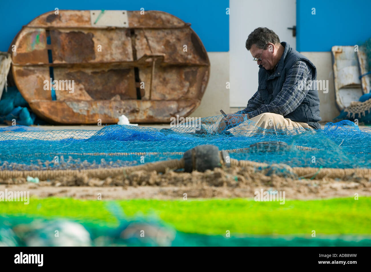 Commercial fisherman mending nets Stock Photo - Alamy