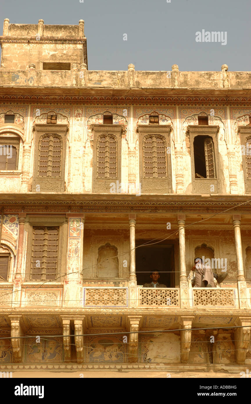 Men looking onto the street from an ancient traditional Indian building ...
