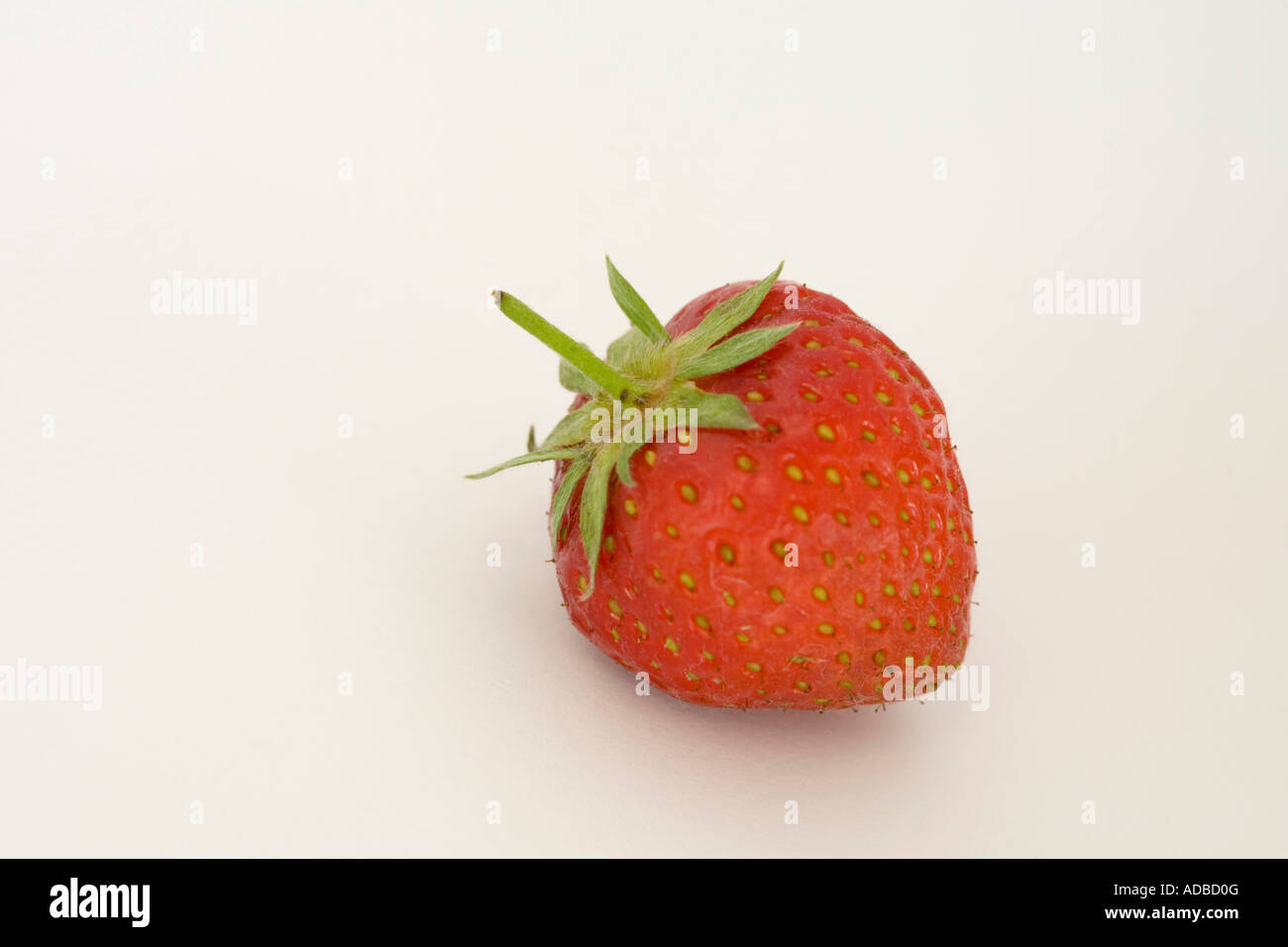 Single strawberry against plain white background Stock Photo - Alamy