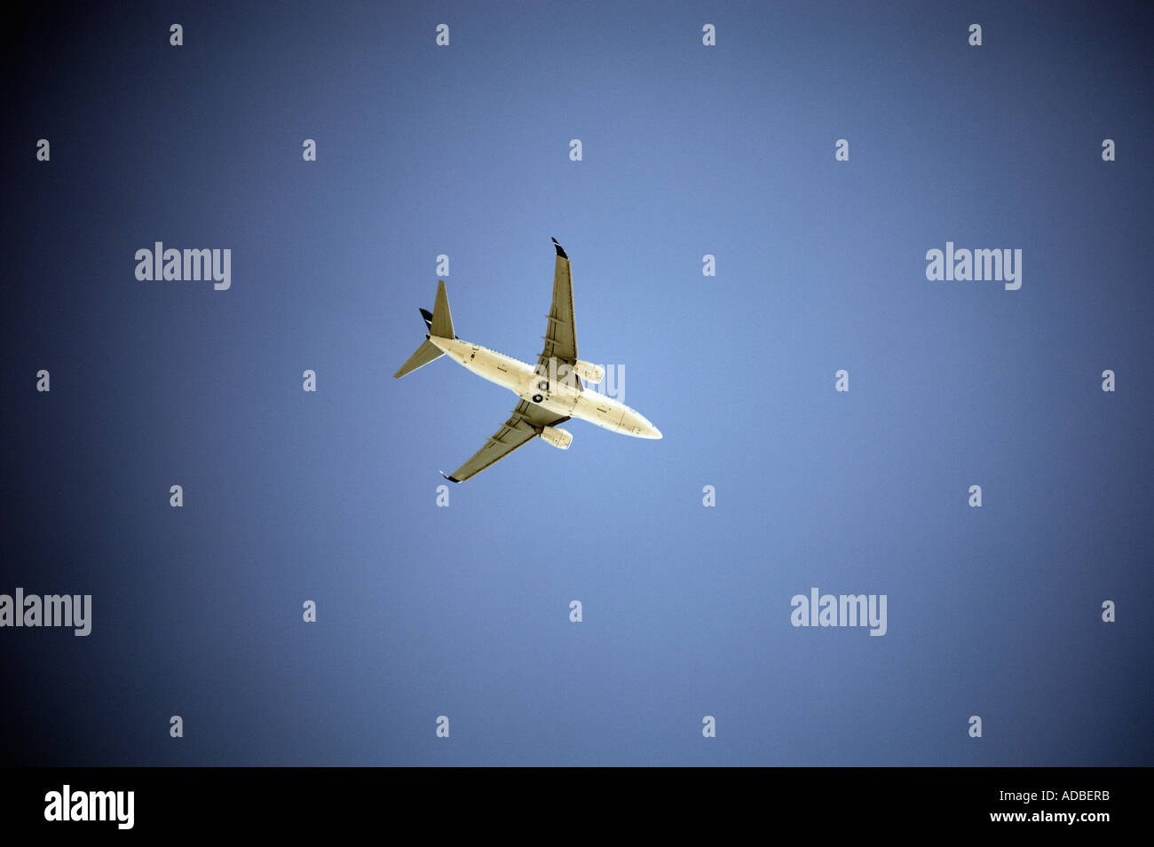 jet airliner flying overhead with blue sky Stock Photo - Alamy