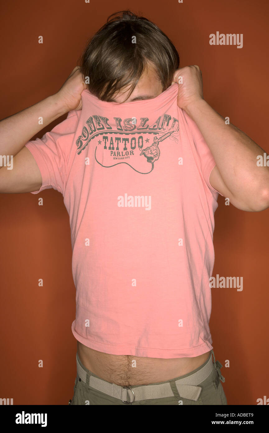 image of young man pulling off his shirt Stock Photo - Alamy
