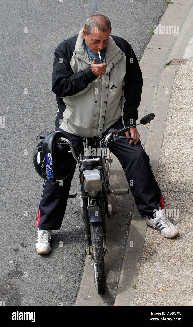 Moped rider stopping for cigarette, France Stock Photo - Alamy