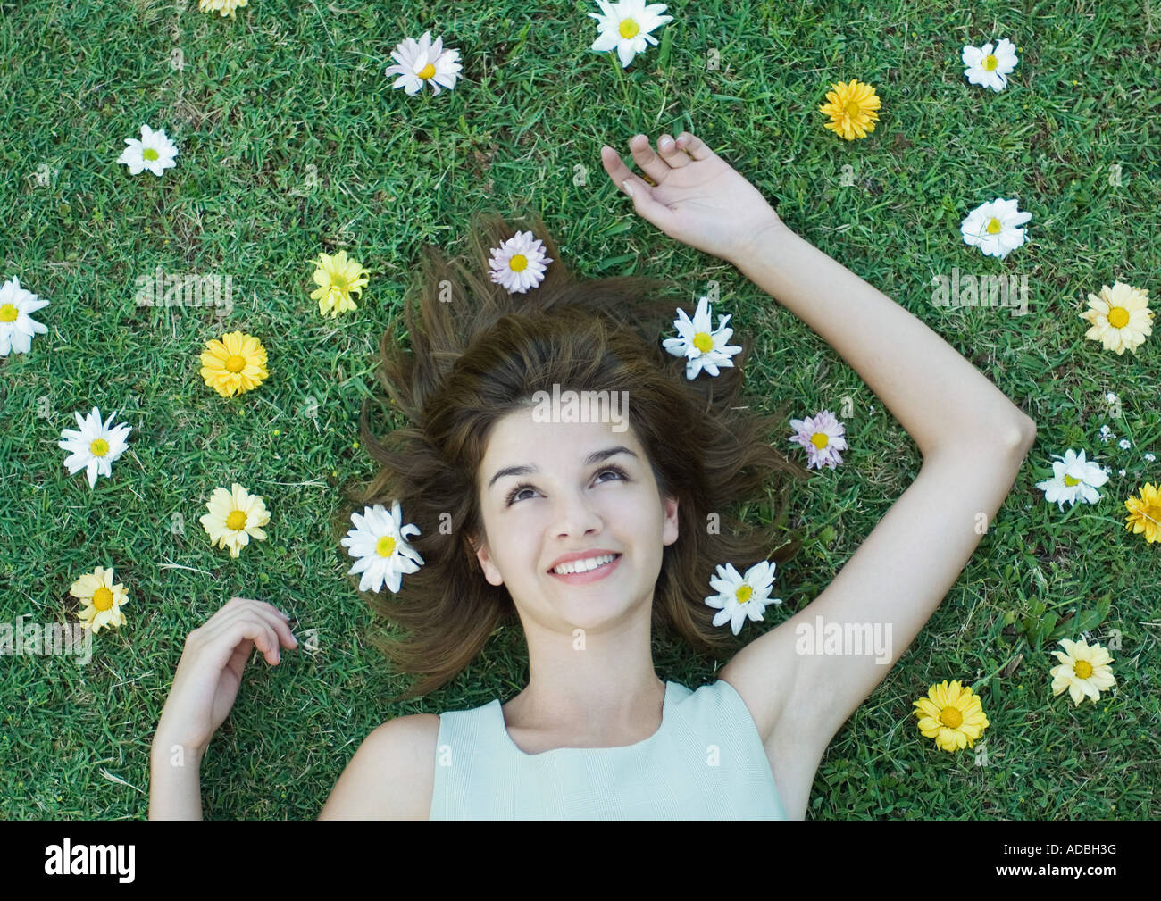 Woman lying on grass with flowers scattered around head Stock Photo - Alamy