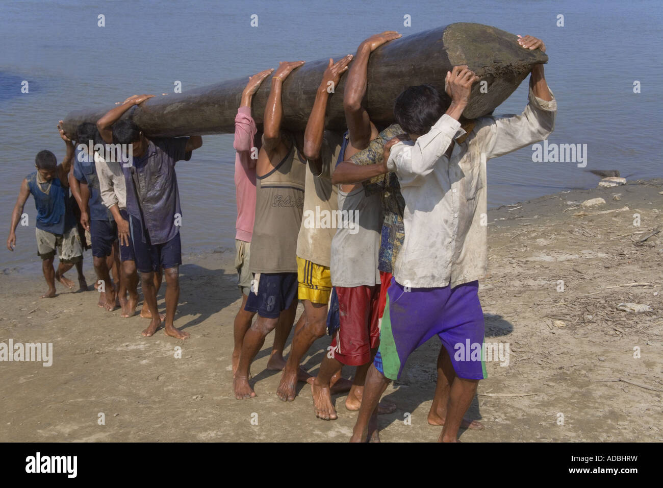 Men carrying log on the beach Myanmar Stock Photo - Alamy