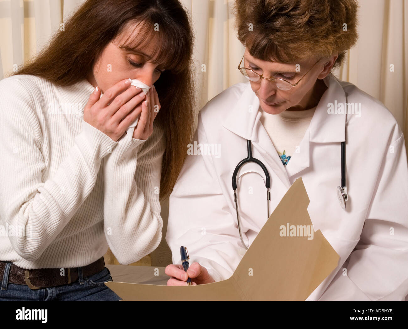 A female Caucasian GP showing a medical report to a sick Caucasian ...