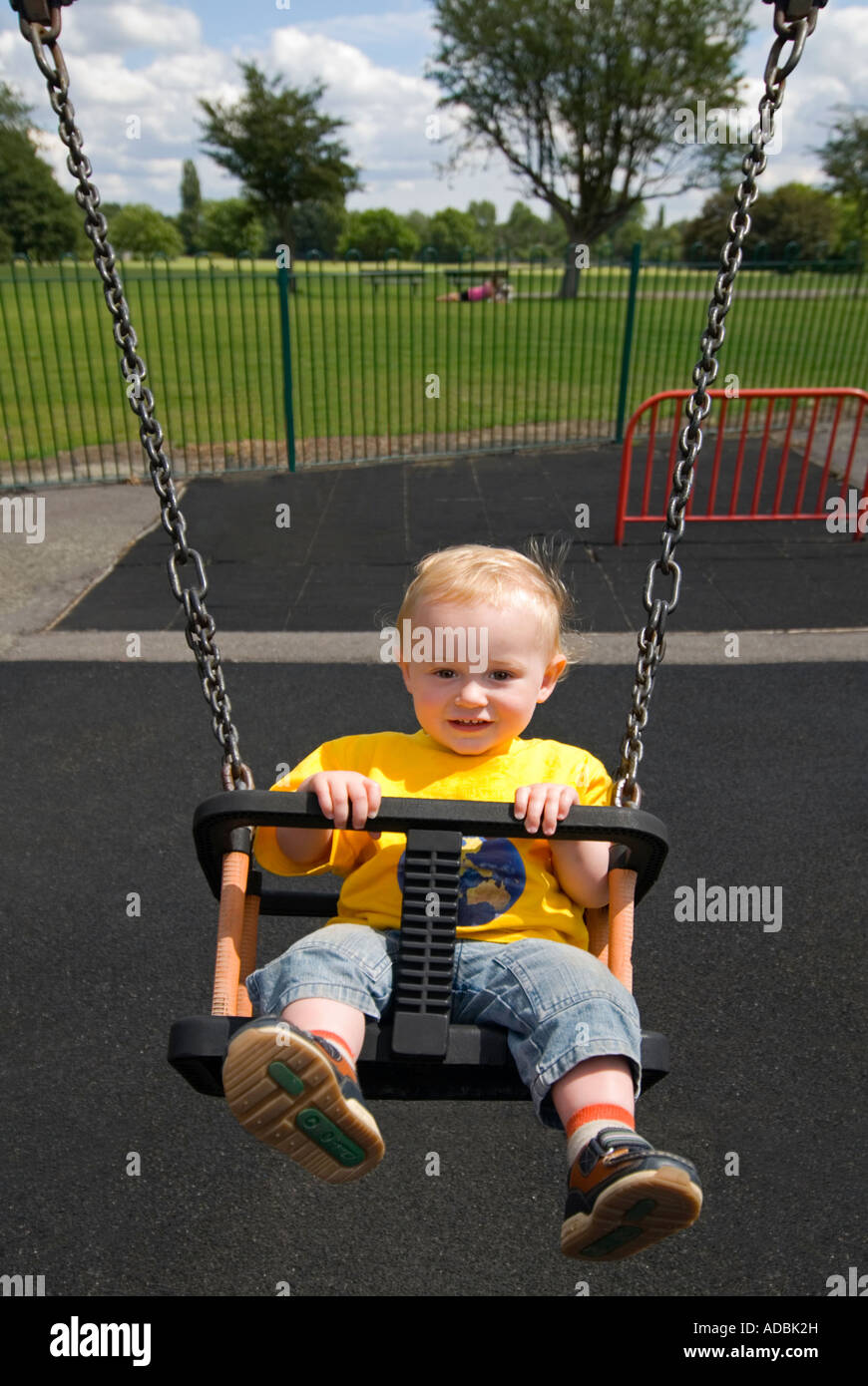 Young child being pushed on swing hi-res stock photography and images ...