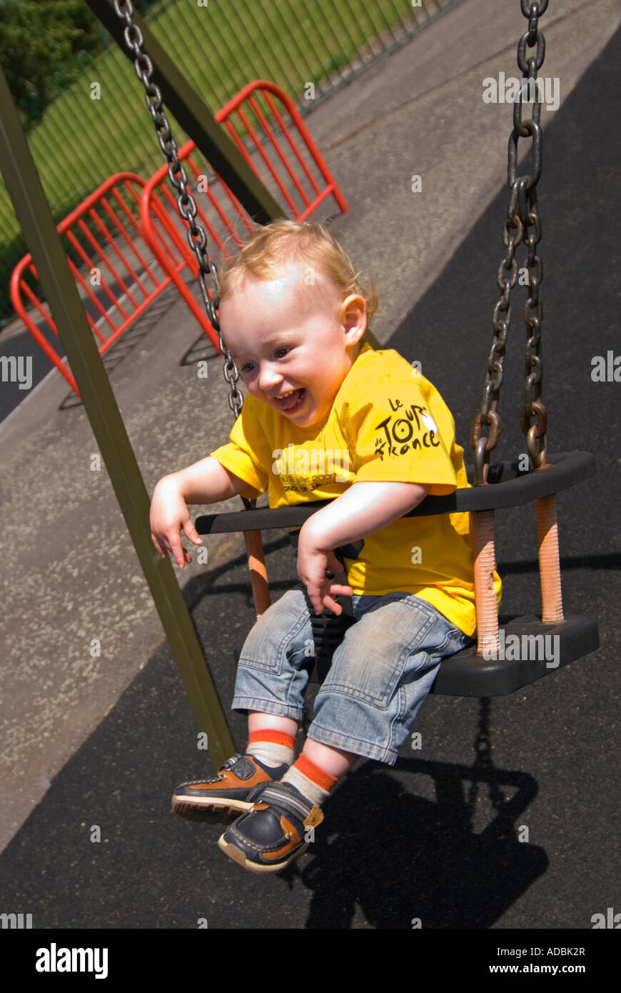 Young child being pushed on swing hi-res stock photography and images ...