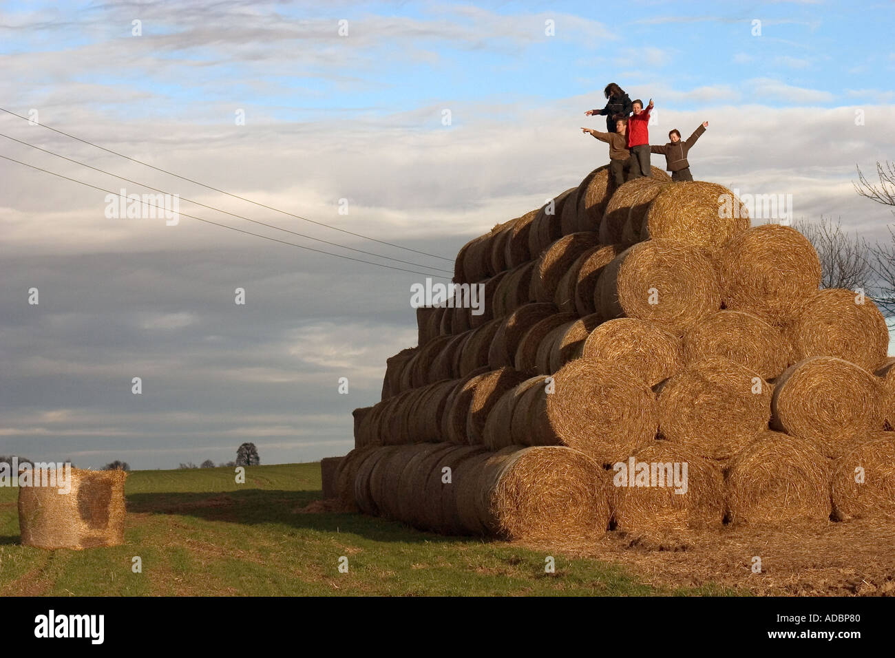 young people at top of a bale of straw pyramid Stock Photo - Alamy