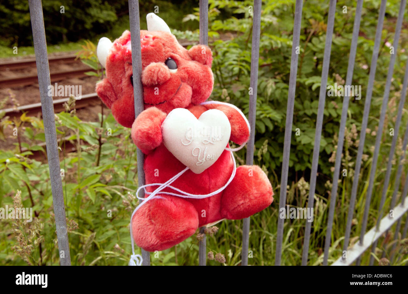 Red Devil soft toy wedged in railings next to the railway line at ...