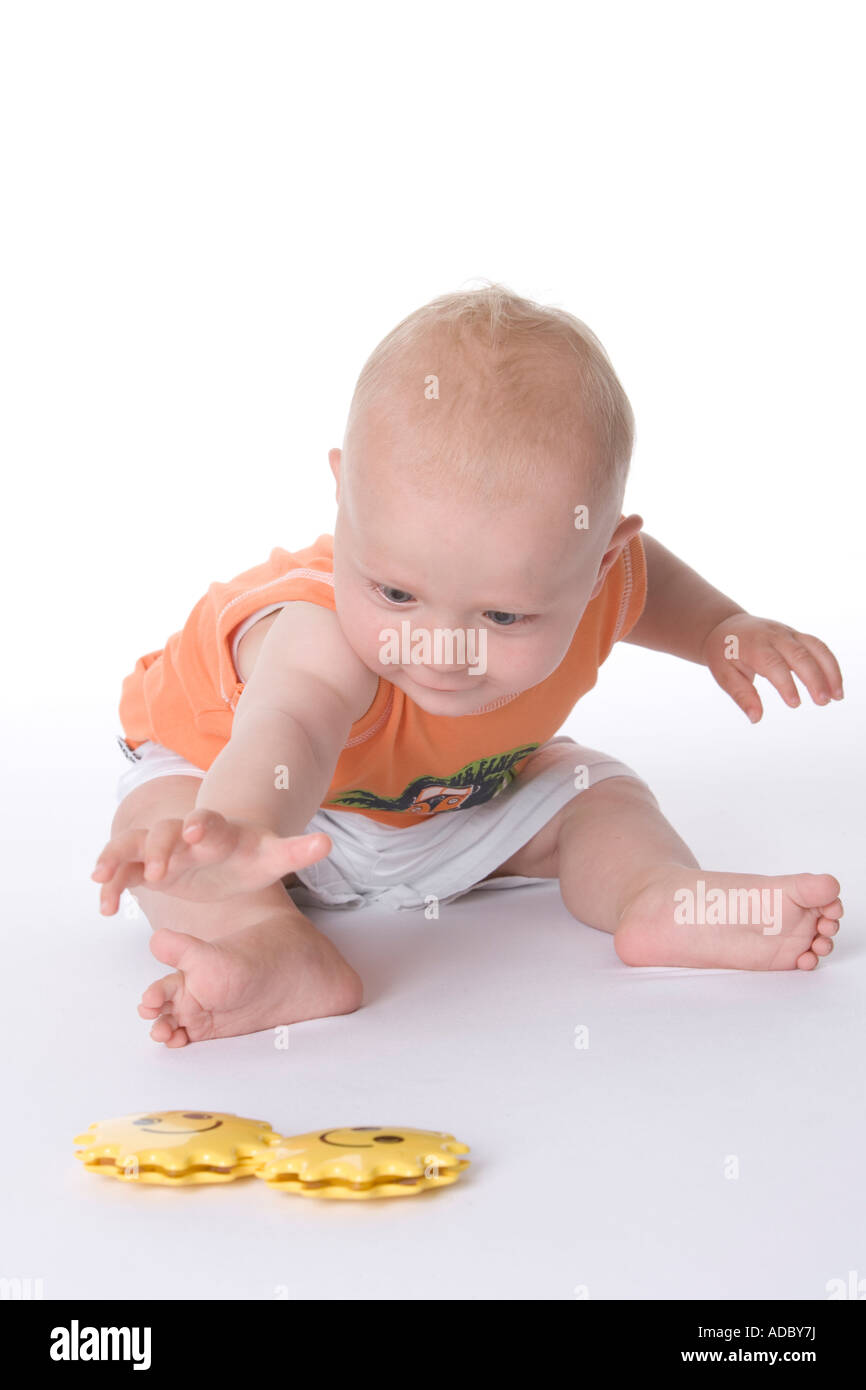 Little boy reaching for a toy Stock Photo - Alamy