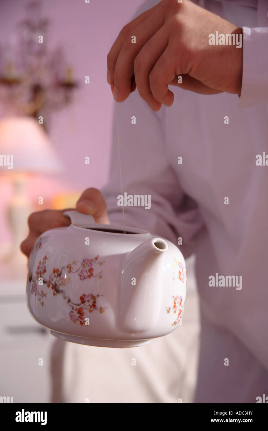 Man taking tea bags out of old fashioned teapot, close up Stock Photo ...