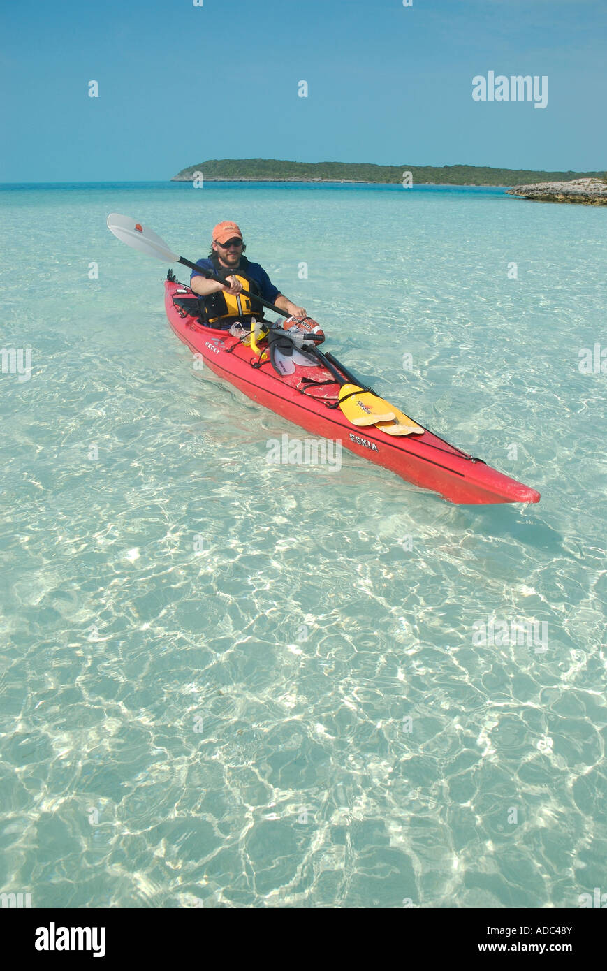 A man kayaks in the pristine azure waters of the Exuma Islands in the ...