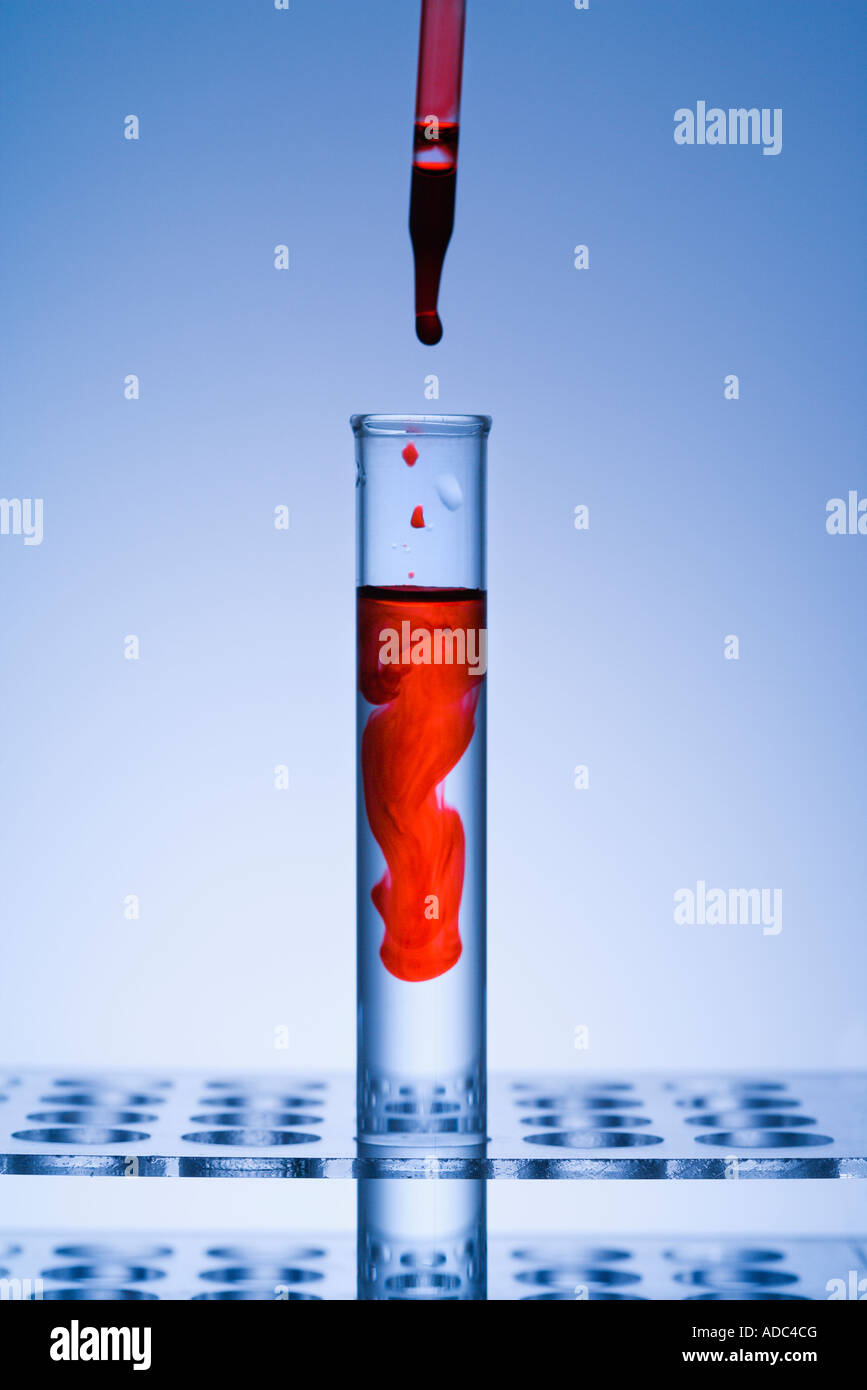 Eye dropper dropping red liquid into glass tube Stock Photo - Alamy