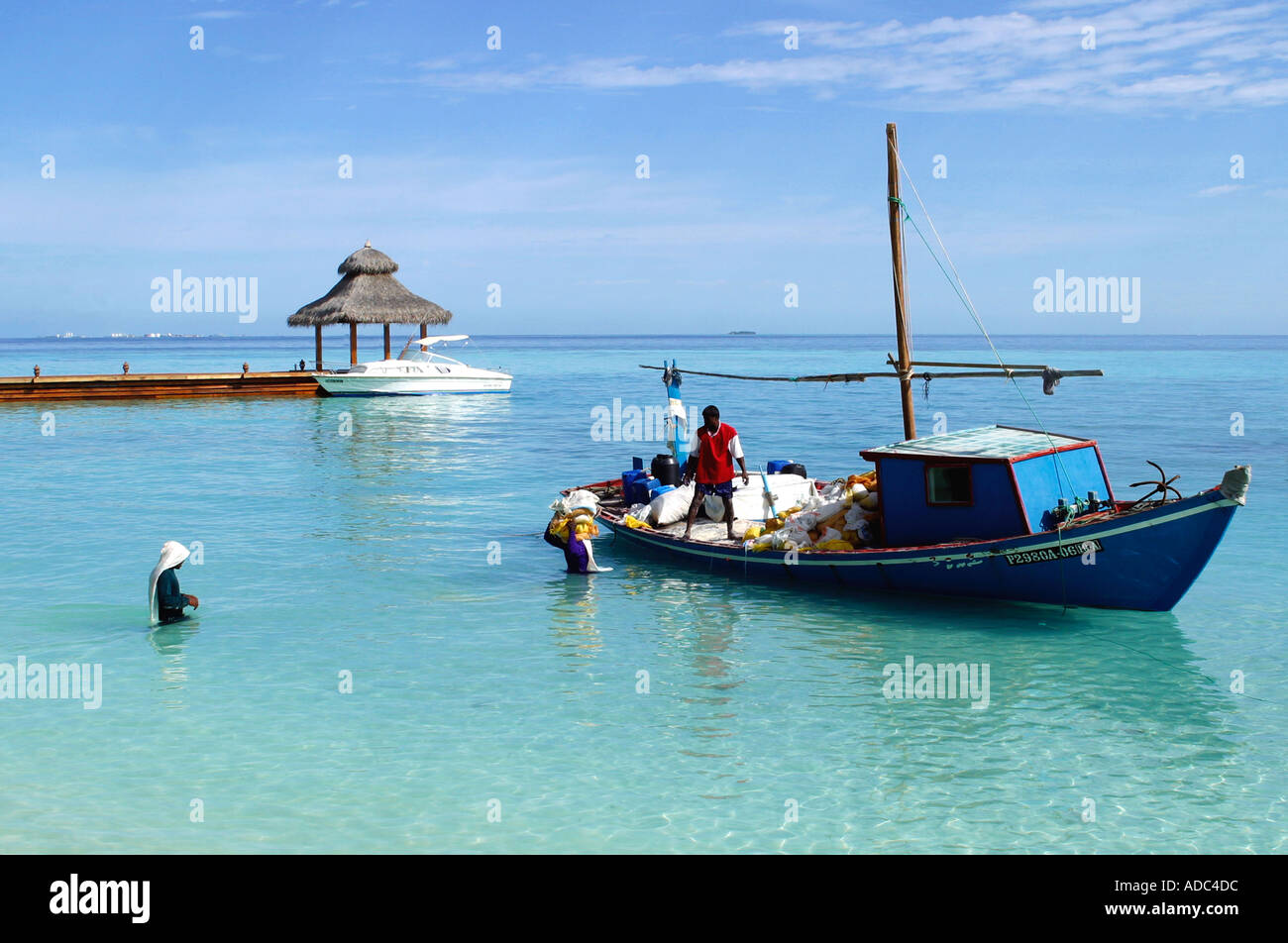 Maldivian s carrying sand from boat to shore in traditional way on ...