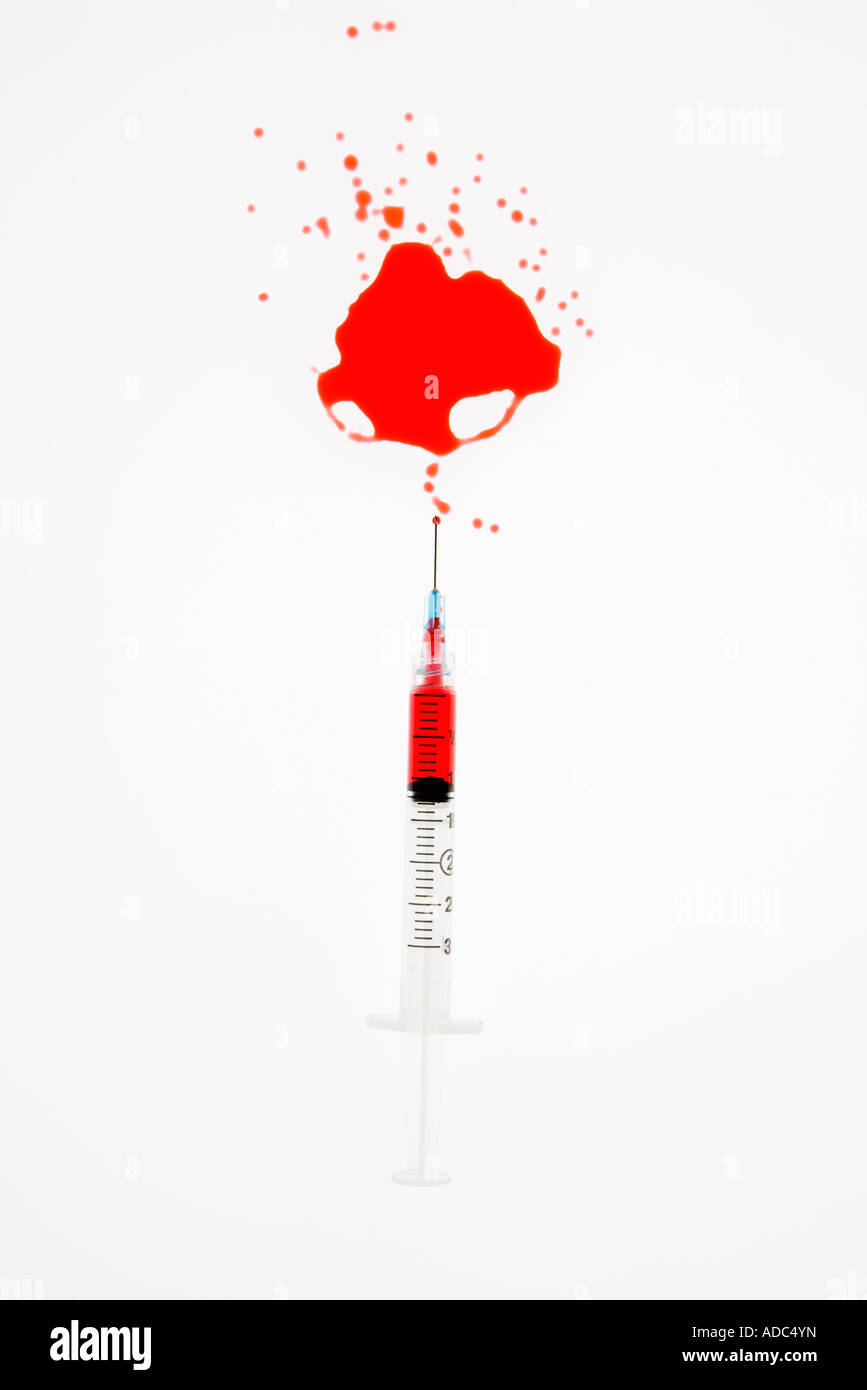 Hypodermic needle with red liquid sprayed on white background Stock ...