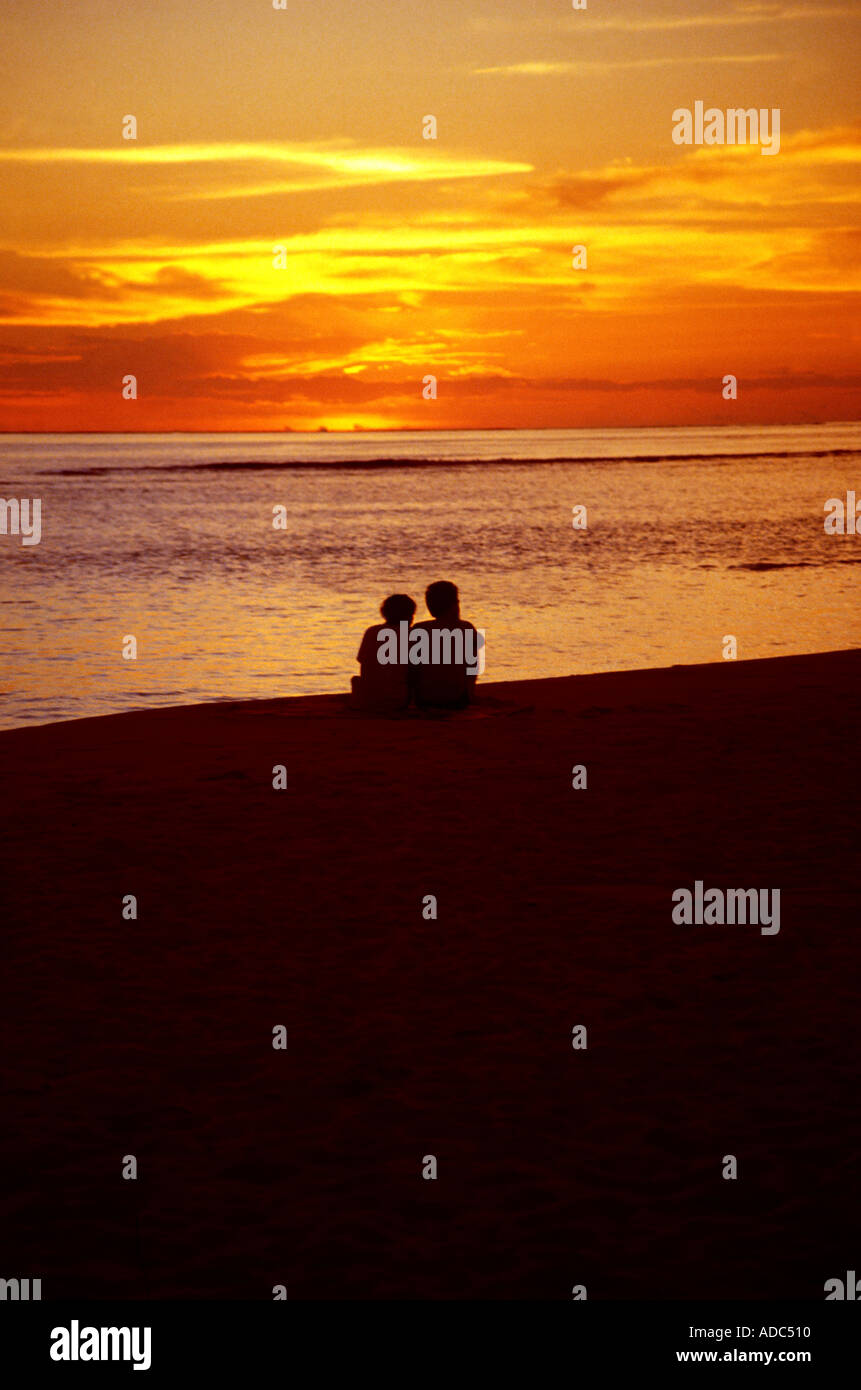 Couple sitting on beach enjoying the sunset Maldives Stock Photo - Alamy