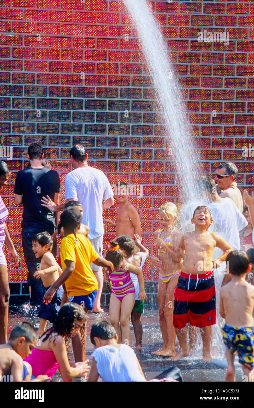 Children enjoy the stream of water cascading from the Crown Fountain at ...