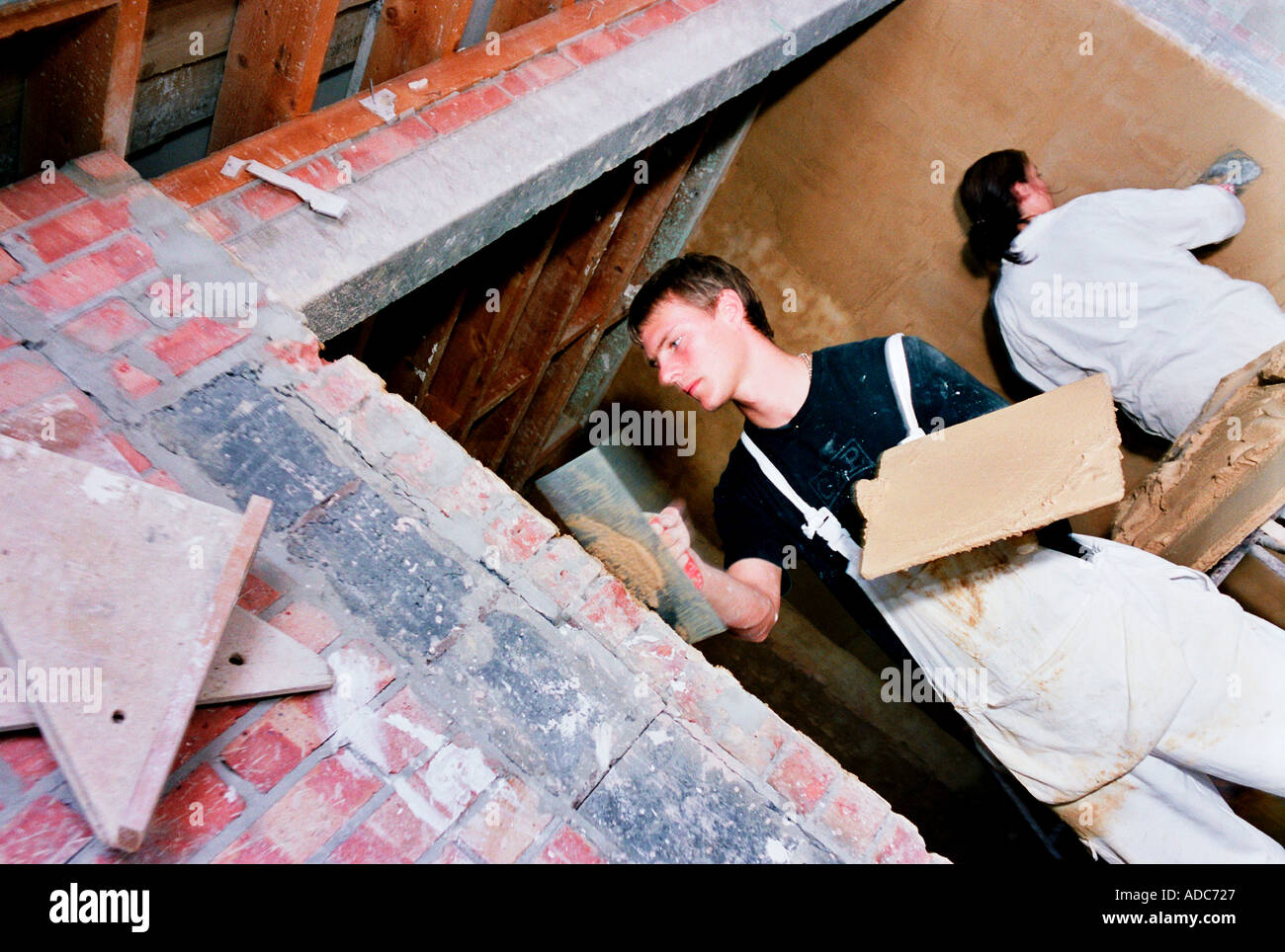 two trainee builders perfect their bricklaying skills Stock Photo - Alamy