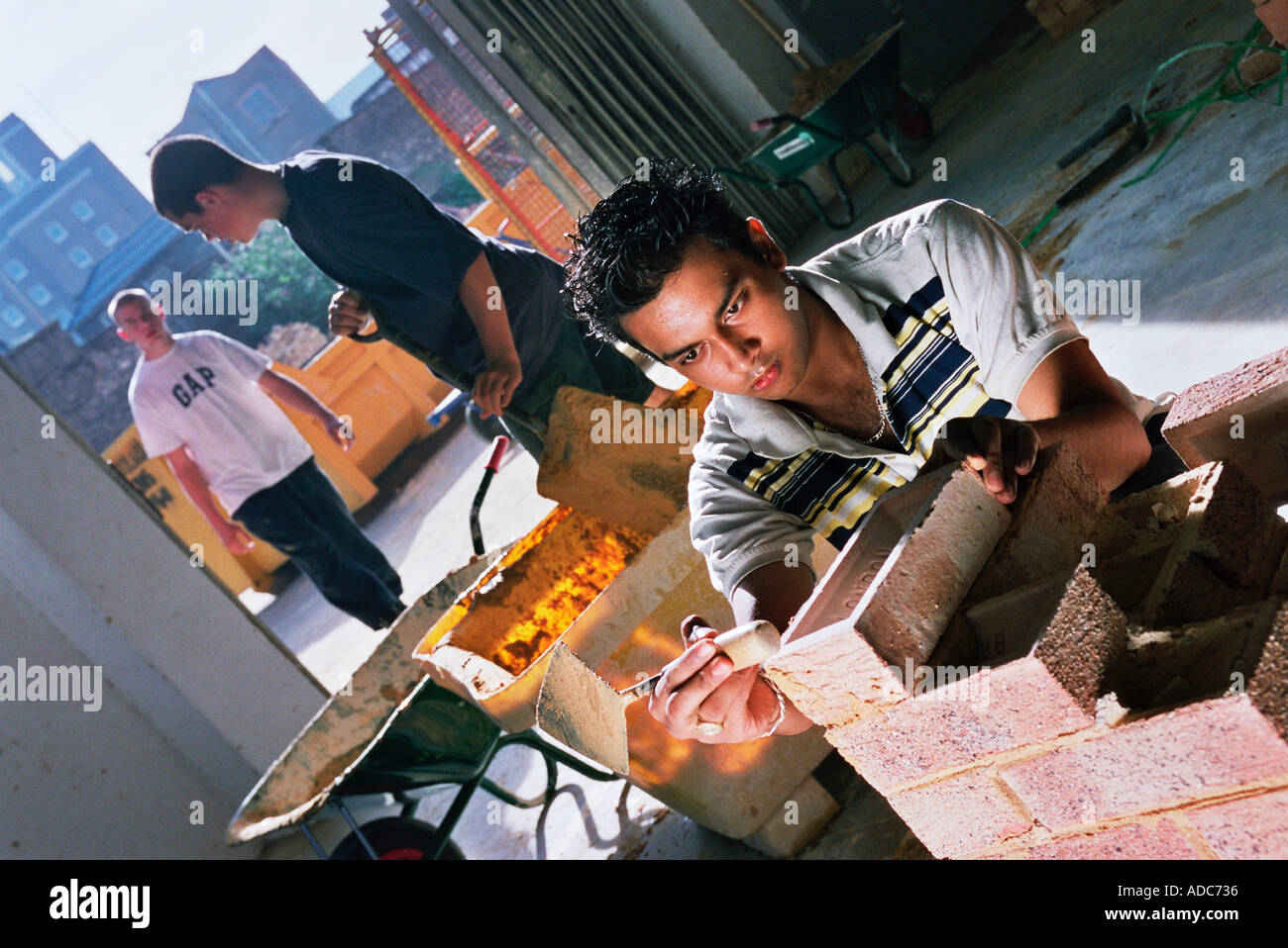 Three student builders working on construction of wall Stock Photo - Alamy