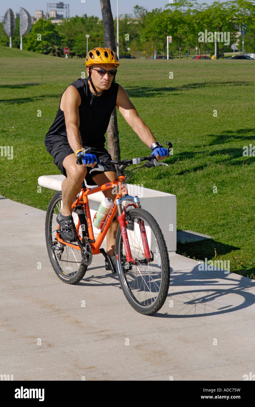 Adult male rides bicycle for exercise along the waterfront in downtown ...