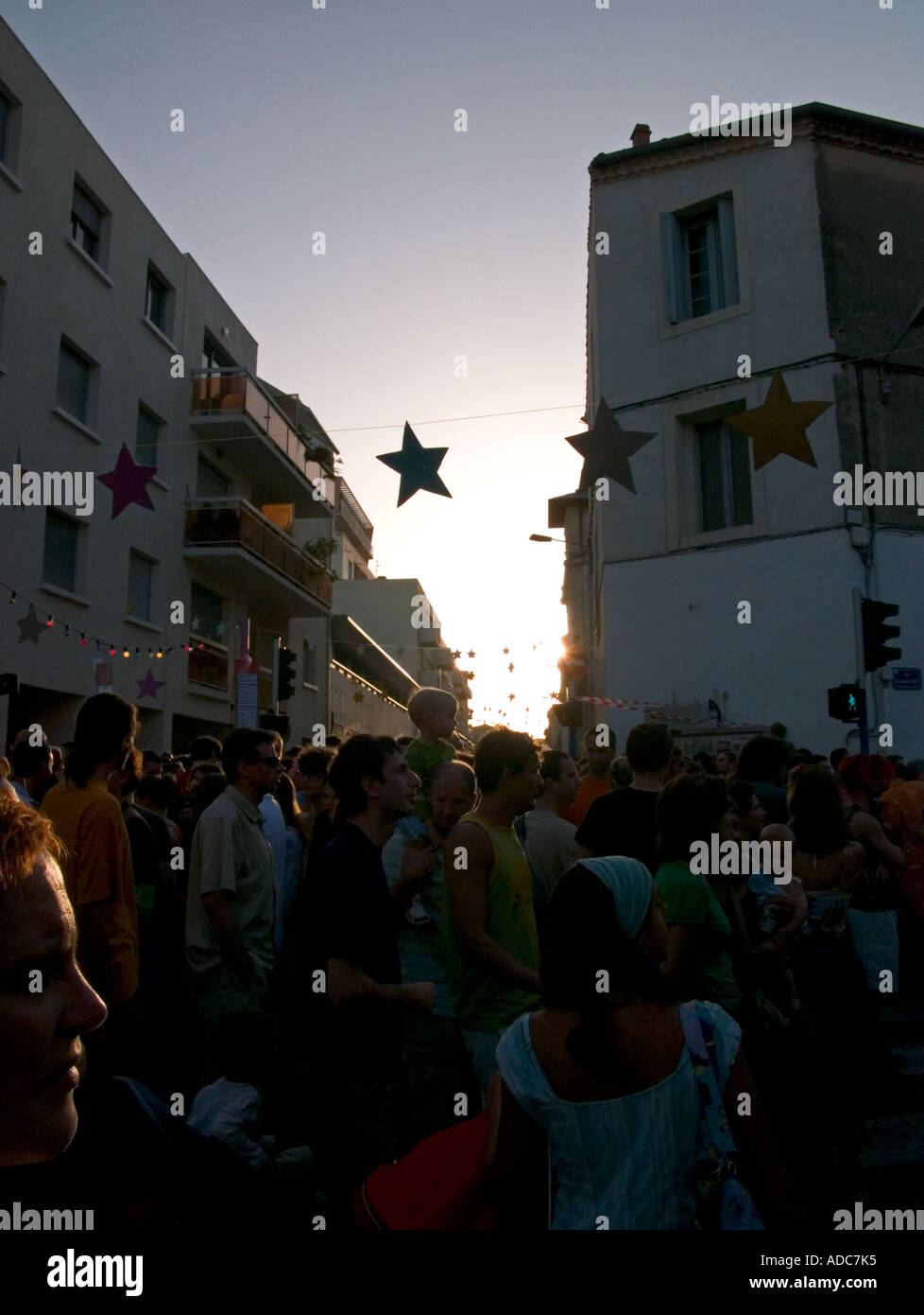 a festive crowd gather under a star during a street festival called ...