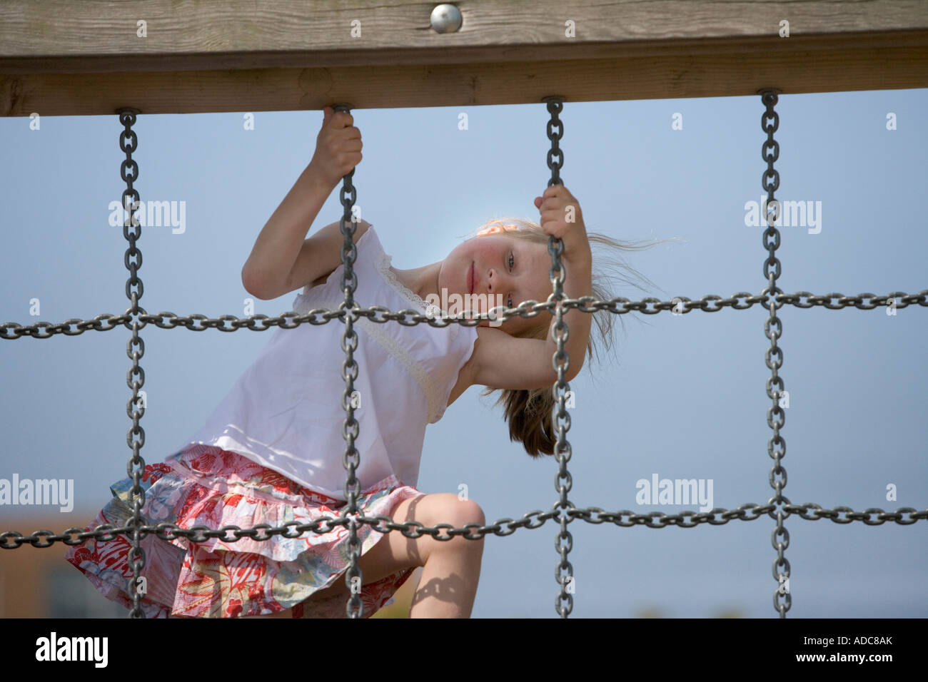 Girl climbing in an iron climbing frame Stock Photo - Alamy