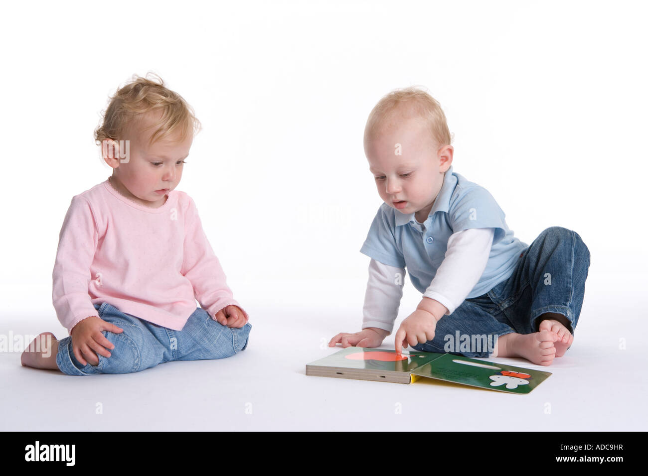 Little boy and girl reading a book together Stock Photo - Alamy
