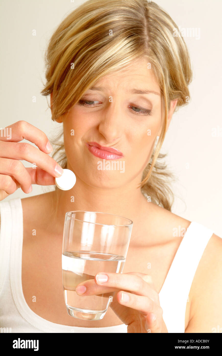 Woman dropping fizzy tablet into glass of water, unhappy Stock Photo ...