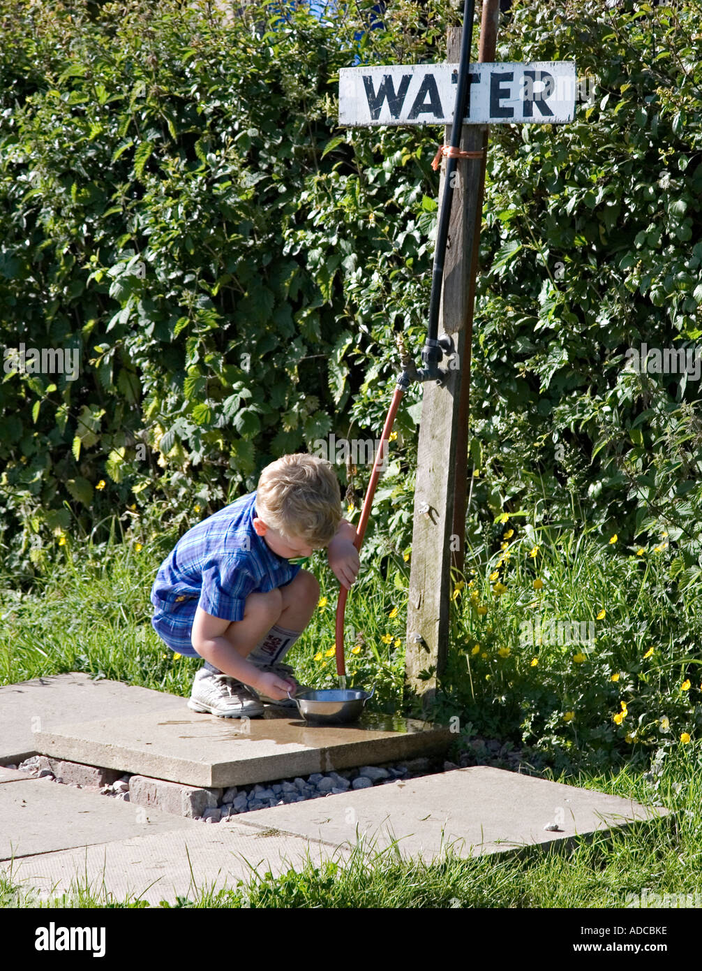 Young child fetching water from a tap on a campsite Wales UK Stock ...