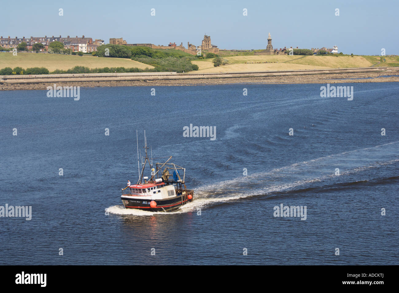 Small traditional British fishing boat passing North Shields promenade ...
