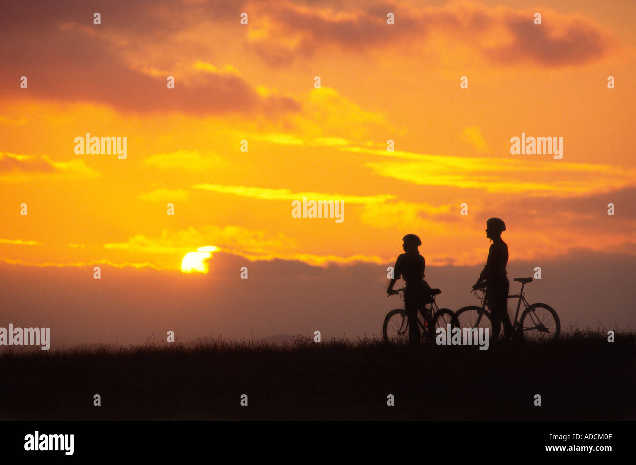 couple watching sunset with Bikes Model released image Stock Photo - Alamy