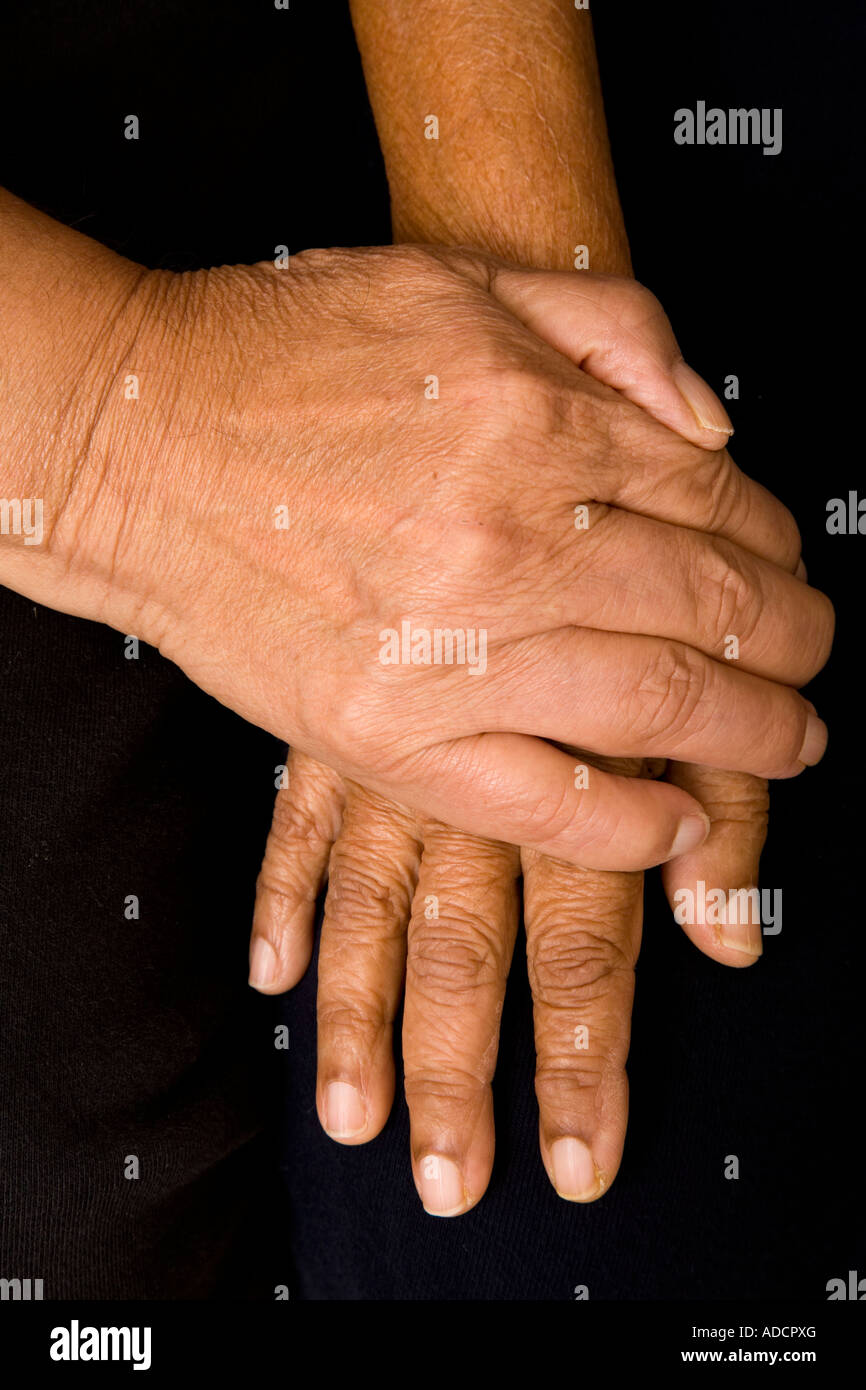 An elderly asian man places a hand on his wife's hand in a comforting ...