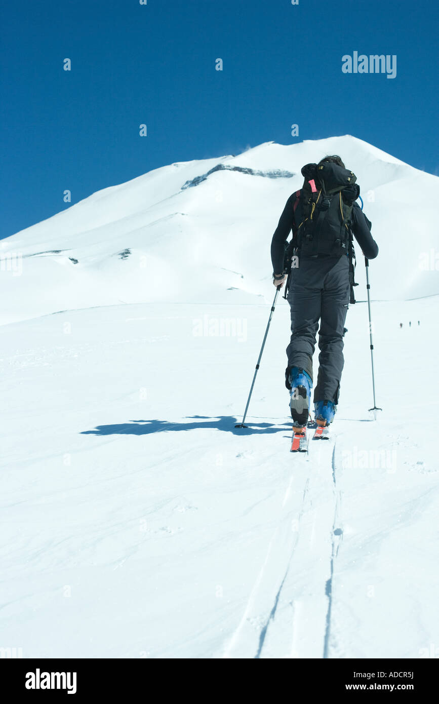 Skier moving uphill Stock Photo - Alamy
