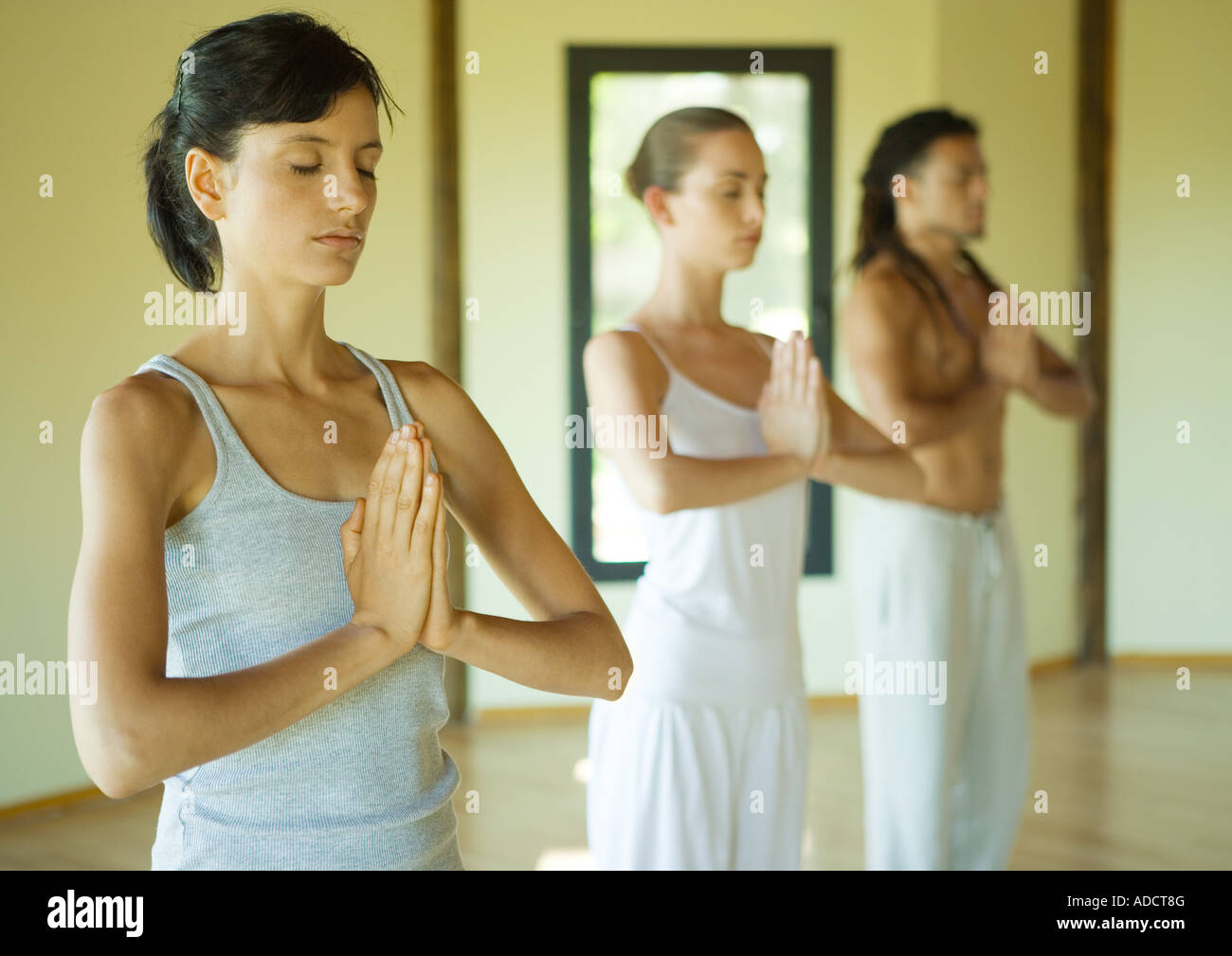 Yoga class standing in prayer position Stock Photo - Alamy
