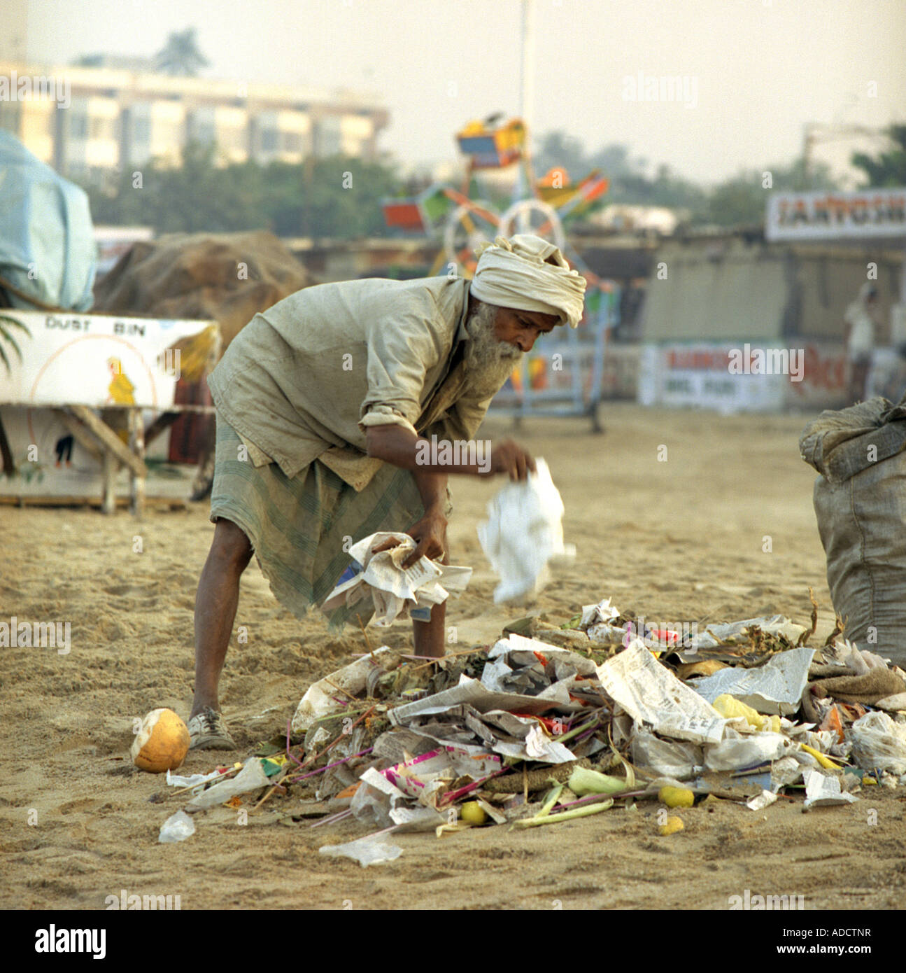 Poor Indian man sifting through rubbish in India Stock Photo - Alamy