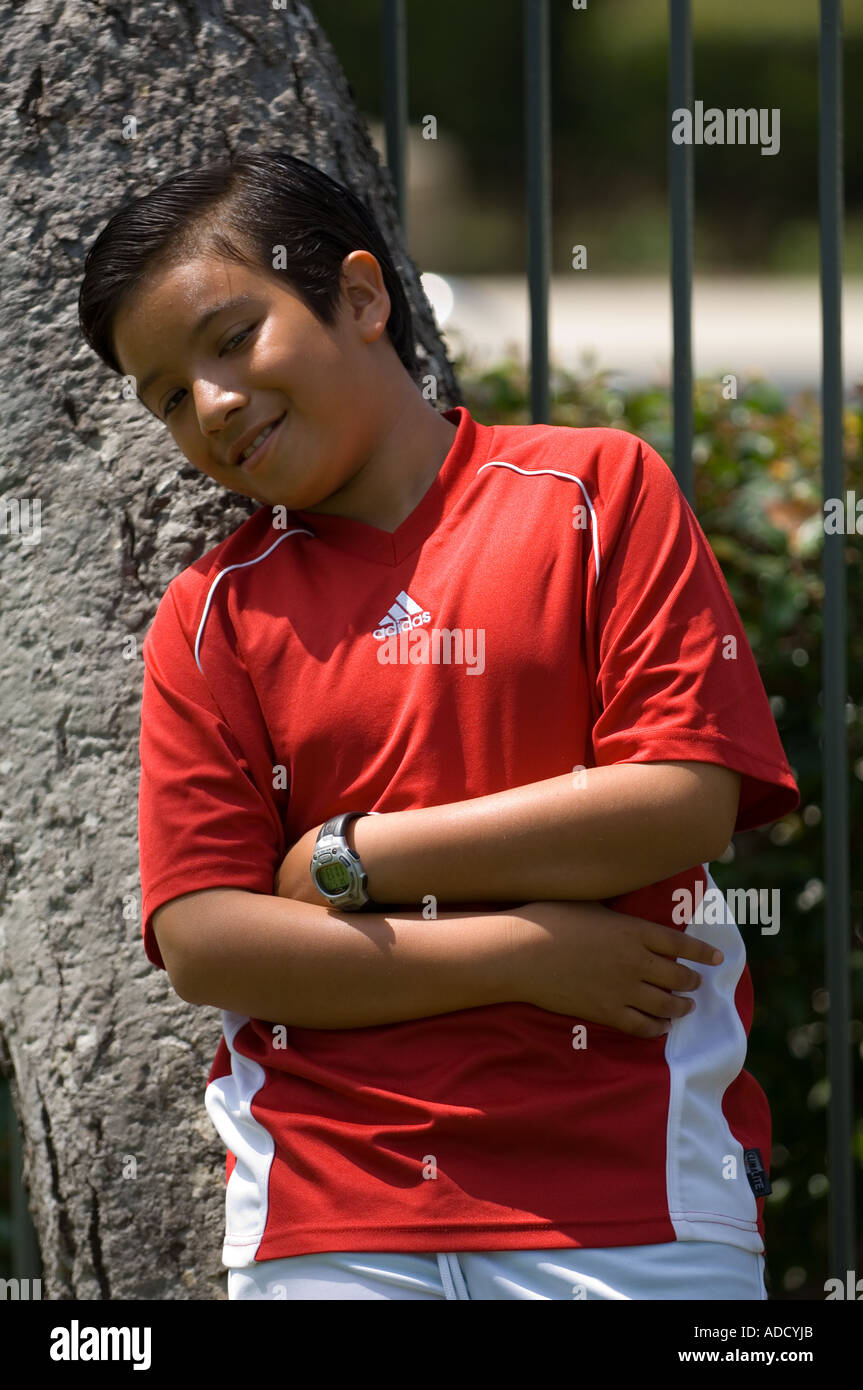 portrait of 8-10 years old boy with arms crossed smiling leaning on ...