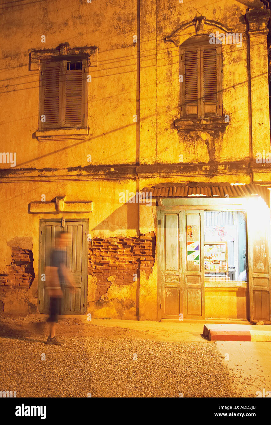 Man Walking Past Crumbling Colonial Building At Night Stock Photo - Alamy