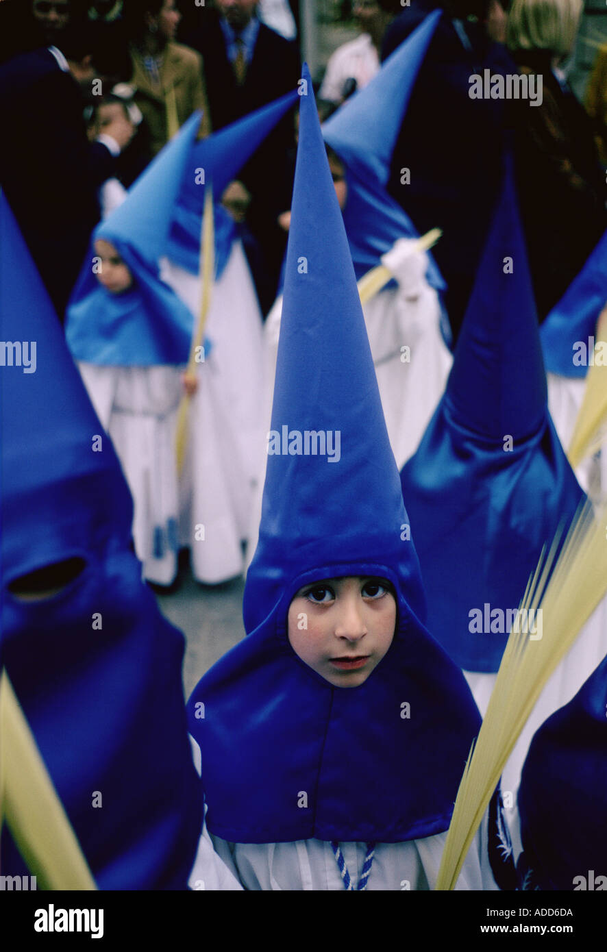 Girl in silk hooded costume with palm leaf in Semana Santa parade Holy ...