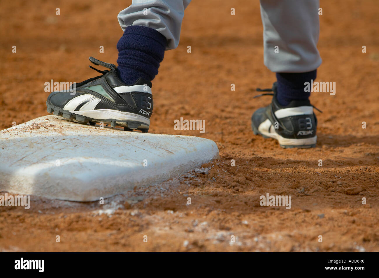 Kid playing baseball with one foot on the base Stock Photo - Alamy