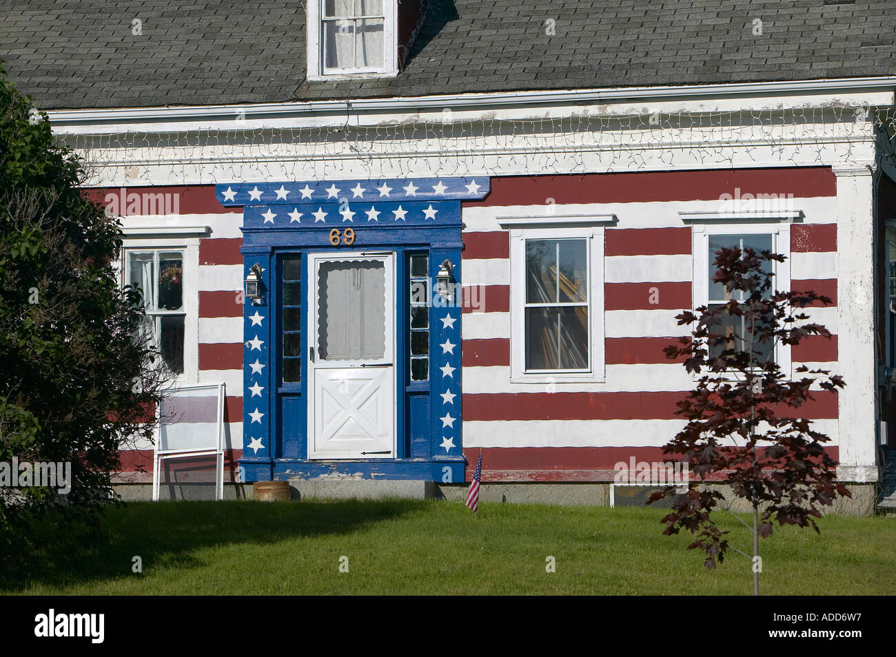 Facade of old salt box style house in rural Maine painted in red white ...