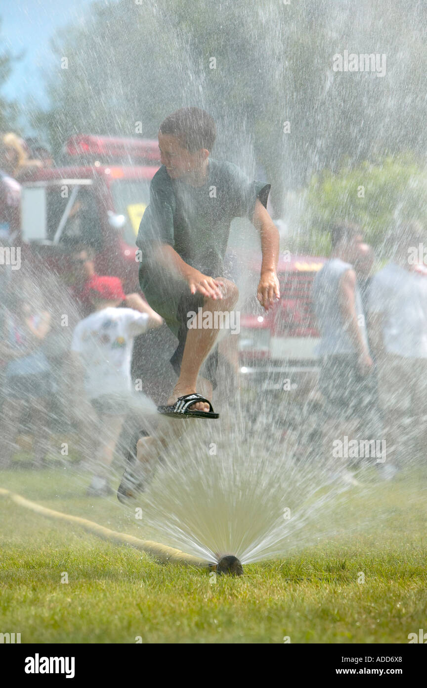 Boy leaps through fire hose spray at 4th of July celebration; firetruck ...