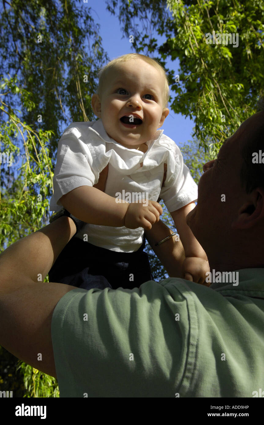 father holding baby boy aloft in his arms Stock Photo - Alamy